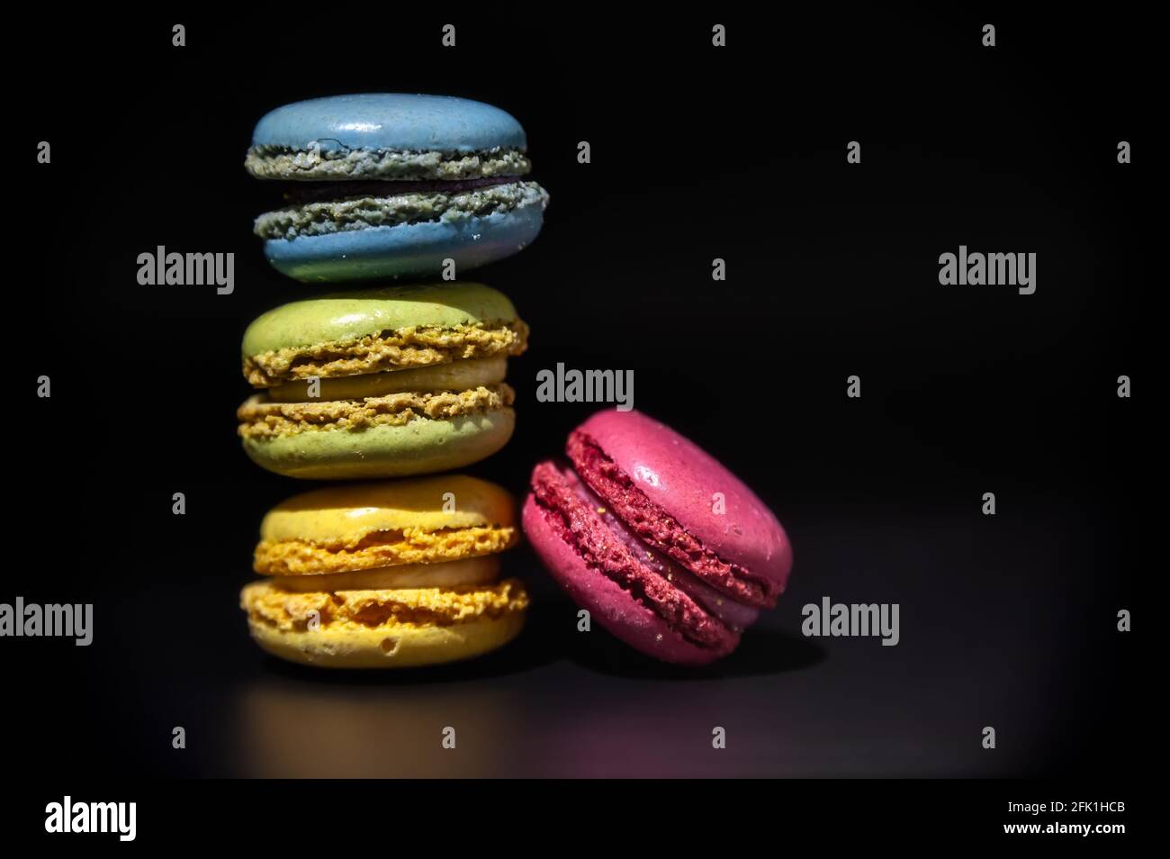 Colorful macaroons against the black background Stock Photo - Alamy