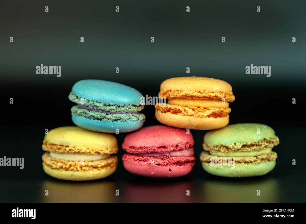 Colorful macaroons against the black background Stock Photo - Alamy