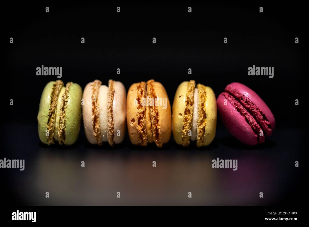 Colorful macaroons against the black background Stock Photo - Alamy