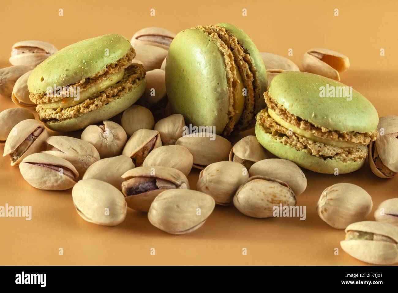 Macaroons in pistachio flavor, with pistachio seeds, against orange ...