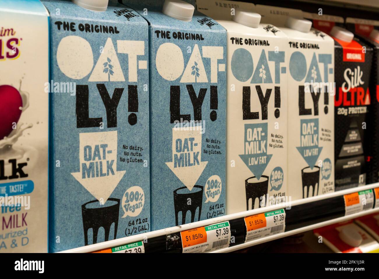 Containers of Oatly! brand oat-milk in a plant-based milk cooler in a ...