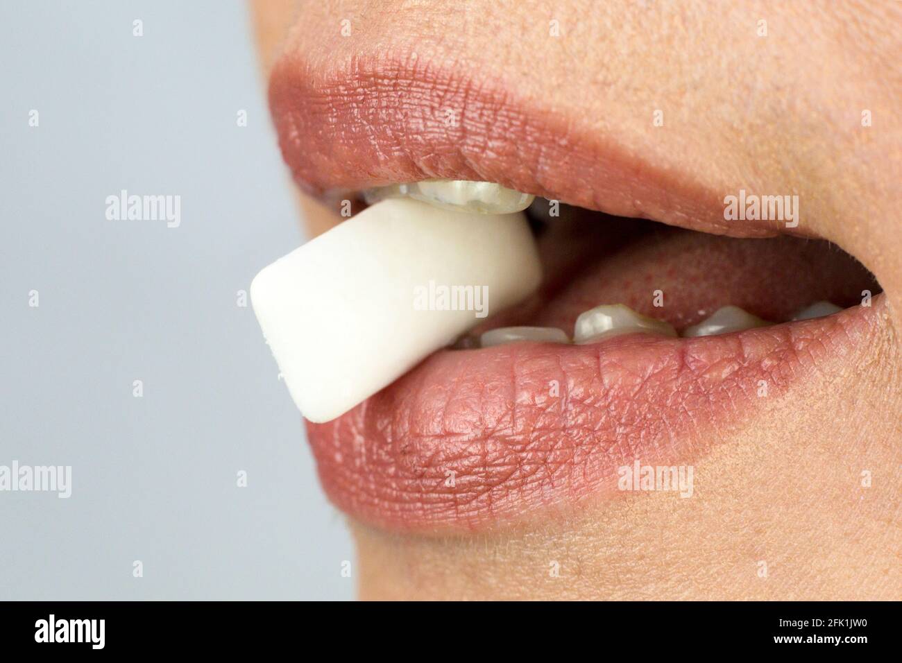 A plate of chewing gum in a woman's teeth close-up Stock Photo - Alamy
