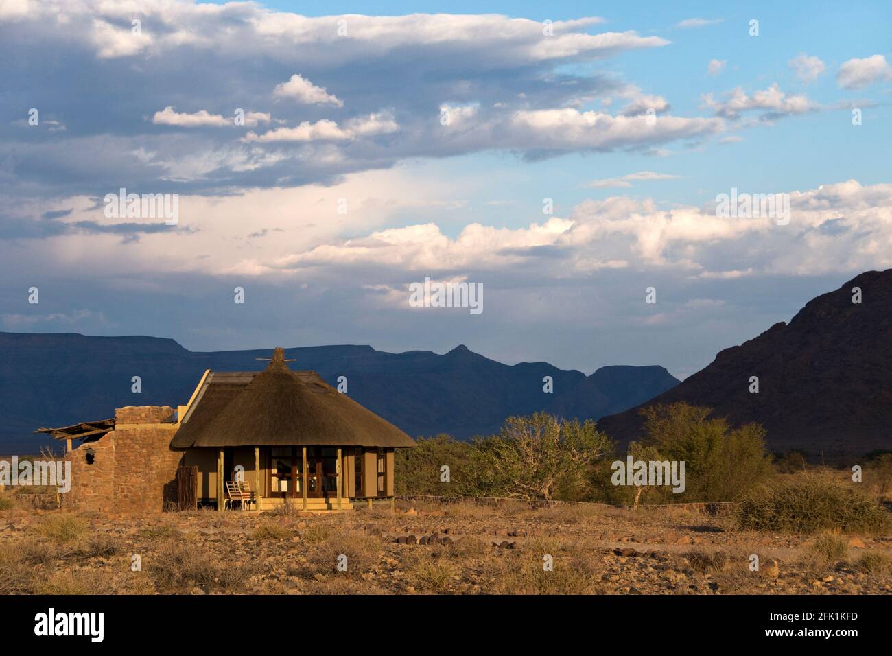Guest rondavels (chalets) at a lodge in the rugged desert landscape ...