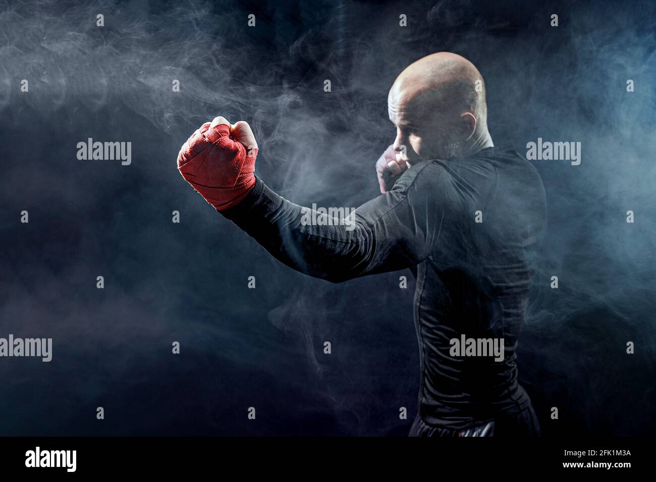 Sportsman boxer fighting on black background with smoke. Boxing Stock ...
