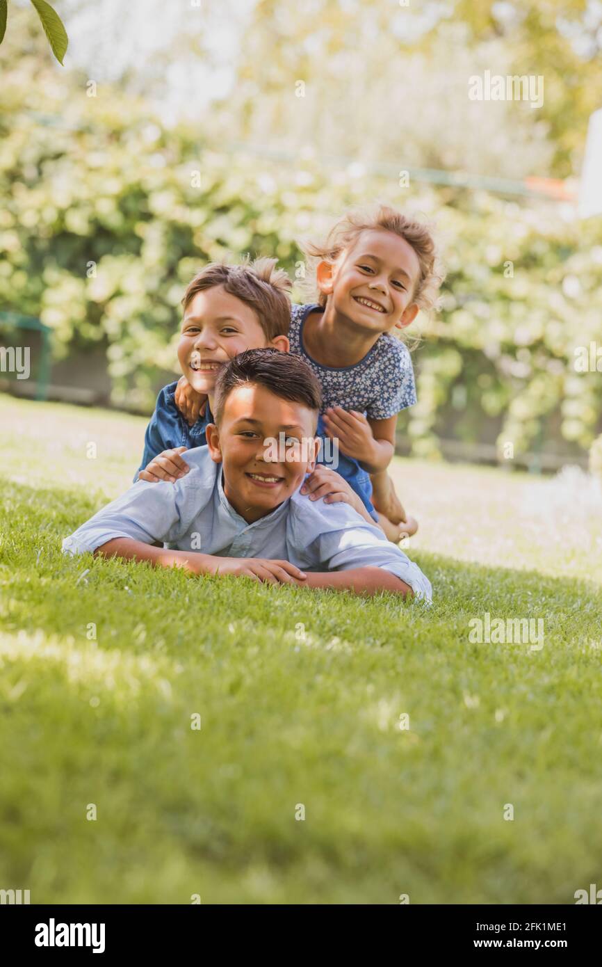 Portrait of three little children as a tower Stock Photo - Alamy