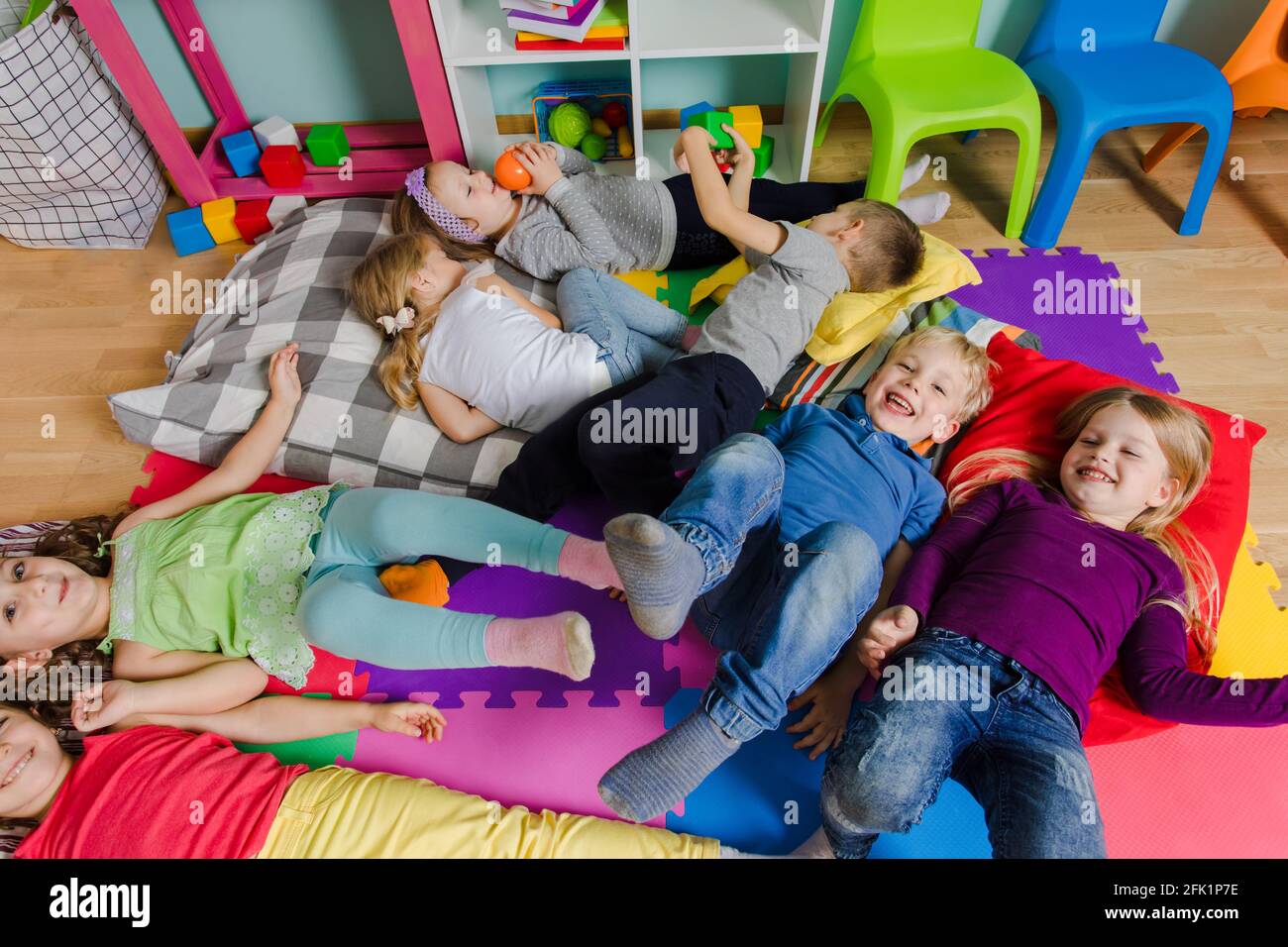 Active kids laying on soft pillows and mats at the kindergarten Stock ...