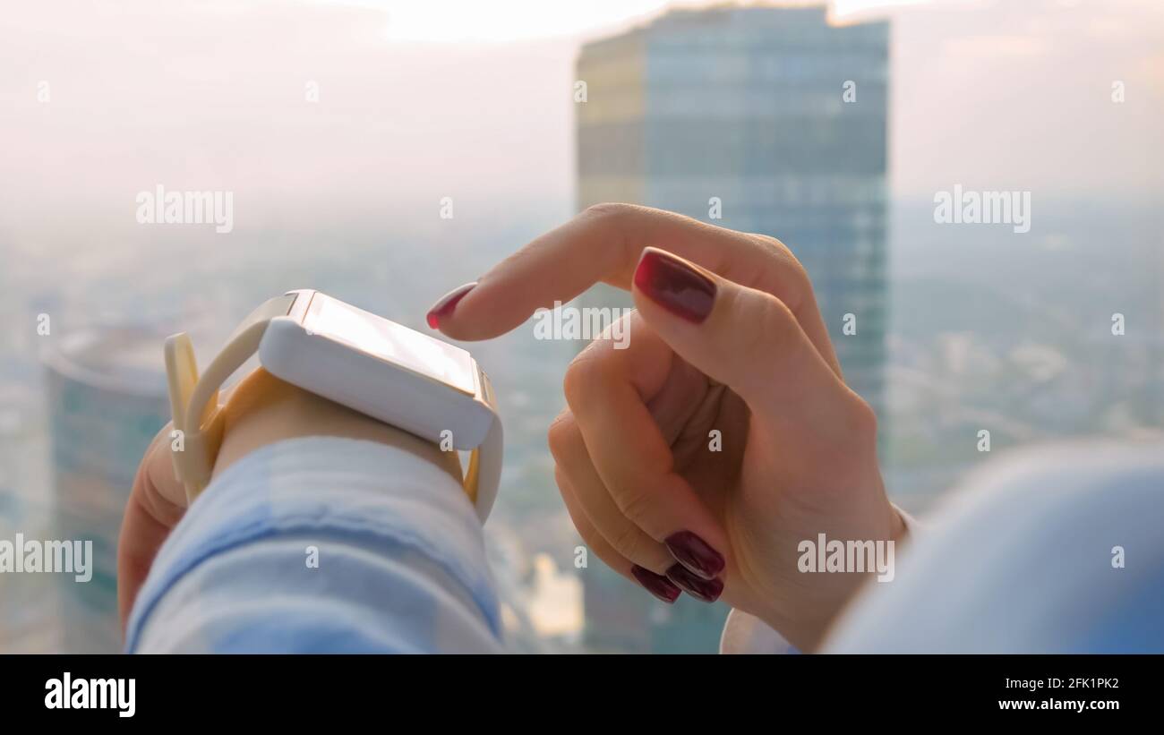 Woman hand using wearable white smart watch in office - close up side ...