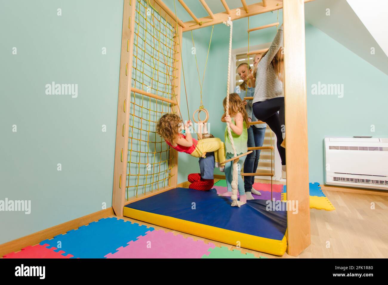 Physical training lesson at a wooden sport complex at the kindergarten ...