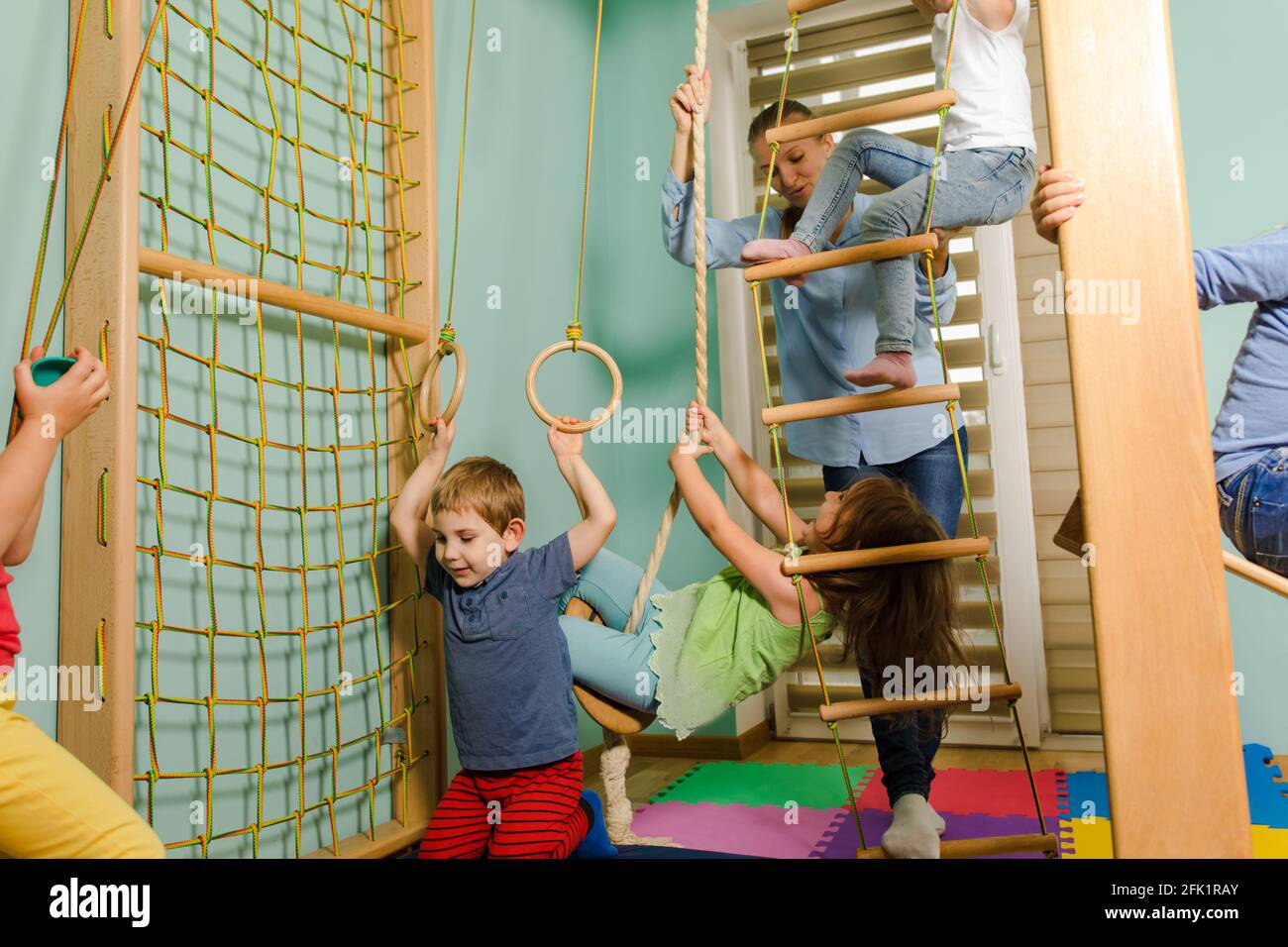 Physical training lesson at a wooden sport complex at the kindergarten ...