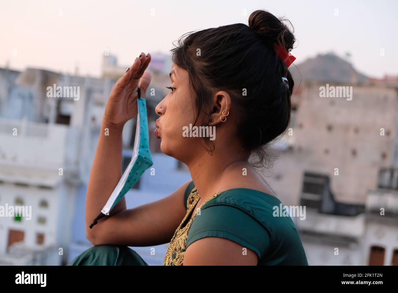 Side portrait of an upset Indian female with a protective mask in her ...