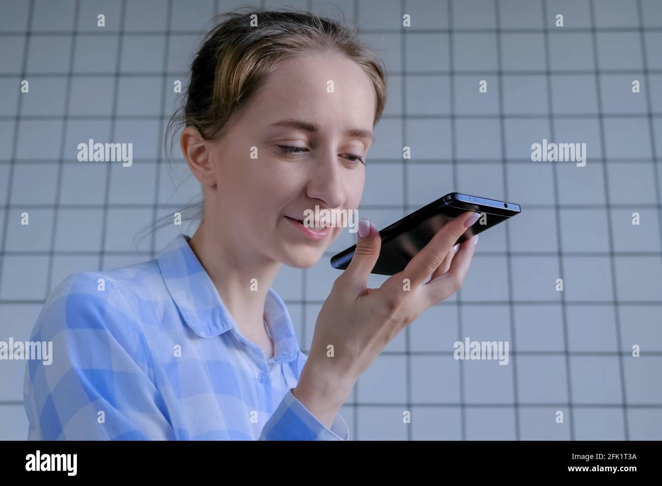 Woman holding smartphone and using voice recognition function Stock ...