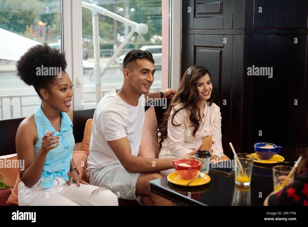 Three friends are talking in a cafe. Friendship, communication ...