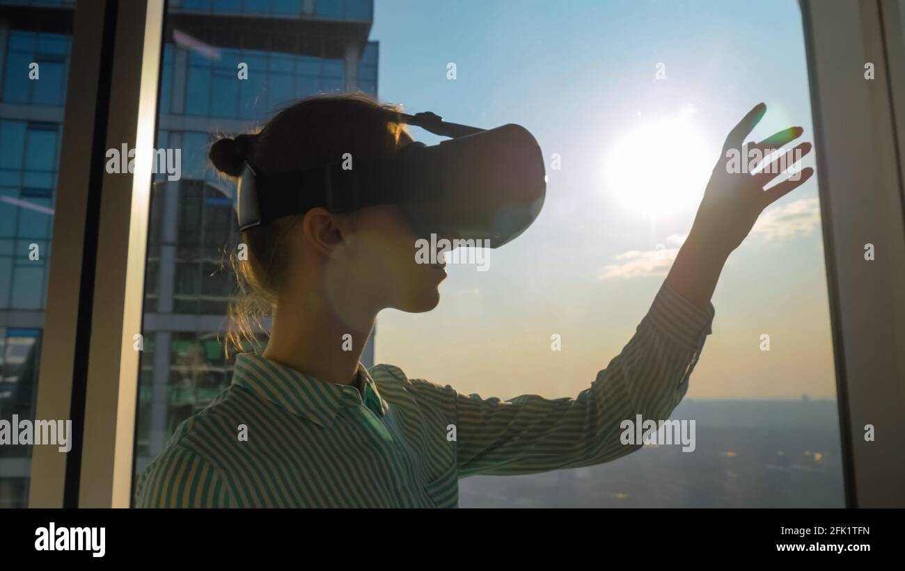 VR concept - young woman using virtual reality headset against ...