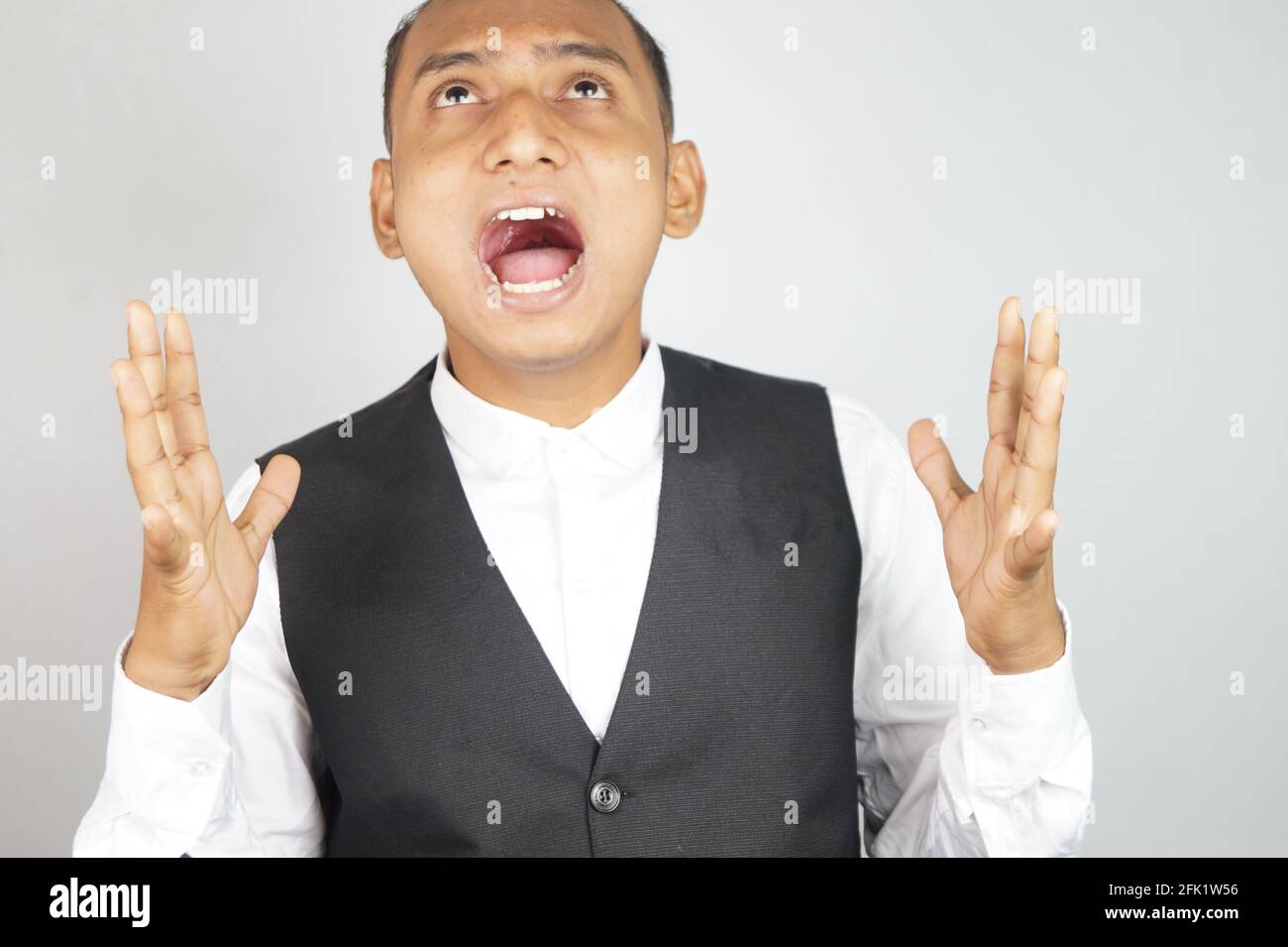 Excited handsome Indian man in formal wear in shock looking up on a ...