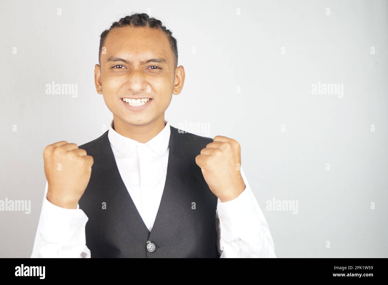 Successful handsome Indian man in formal wear smiling at the camera on ...