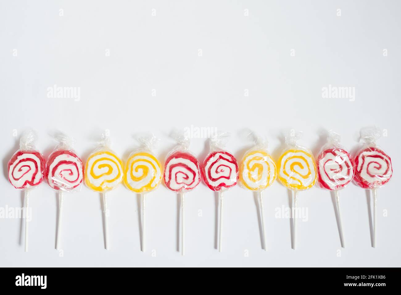 Pattern with red and yellow lollipops in a row. White background Stock ...