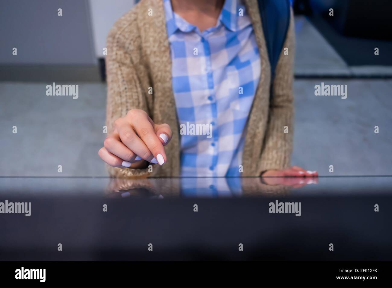 Woman using multimedia touchscreen display of interactive kiosk at ...