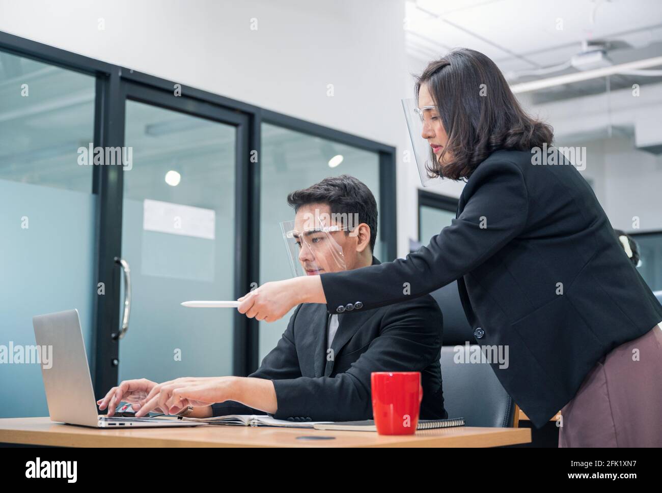 Bossy manager female ordering and pointing at laptop of office male ...