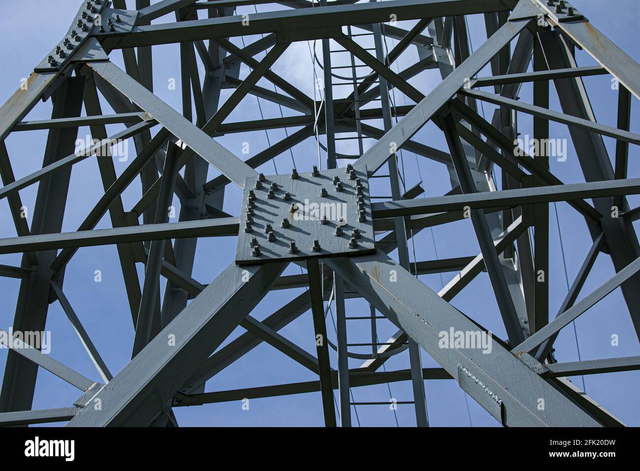 Silhouette of a power line pylon against the blue sky. Transmission of ...