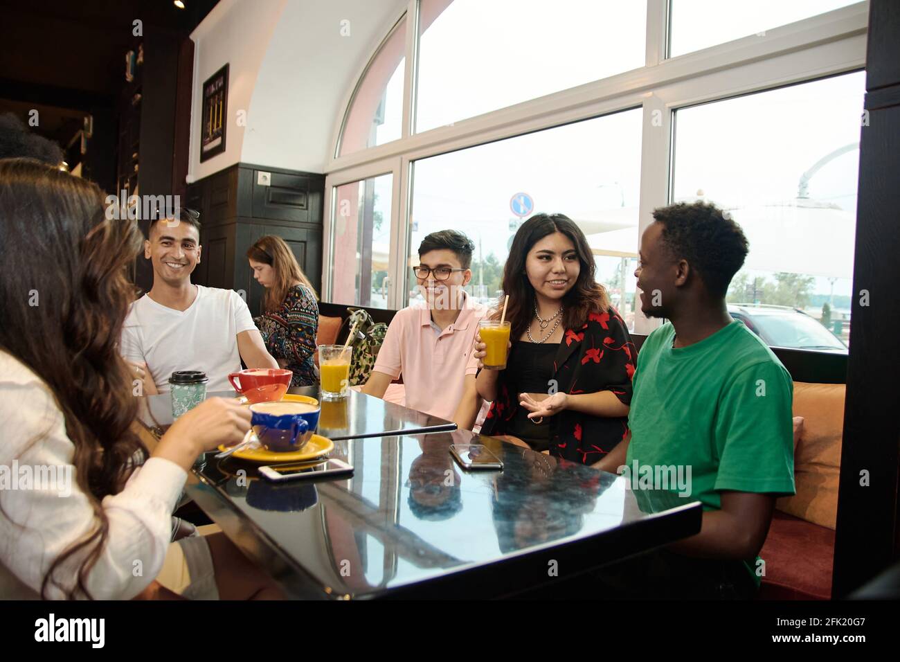 Multiracial happy young people drink coffee at cafe, black and white ...