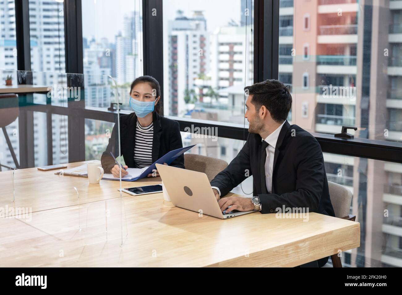 Caucasian supervisor businessman consulting with asian secretary woman ...
