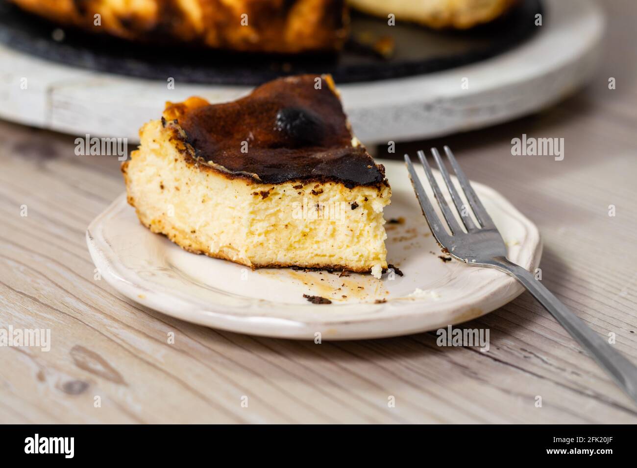 Basque burnt cheesecake piece on the plate Stock Photo - Alamy