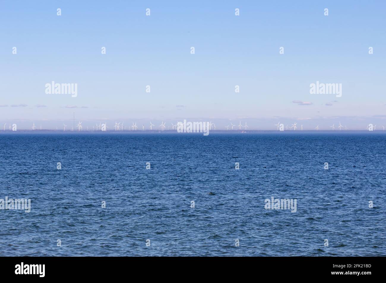 View from open water of a wind farm on shore as seen from a ferry. Wind ...