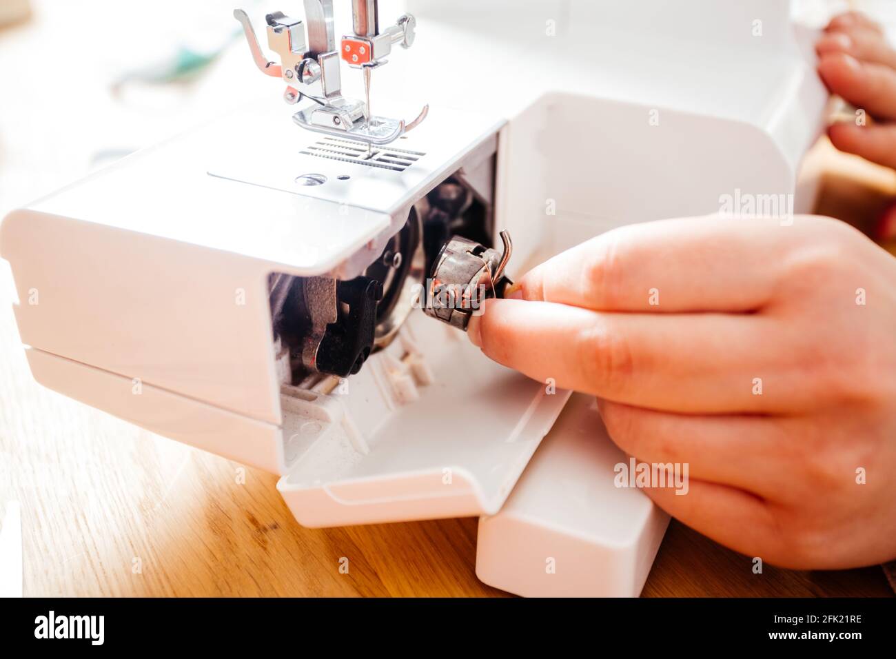 Putting the metal spool into sewing machine Stock Photo - Alamy