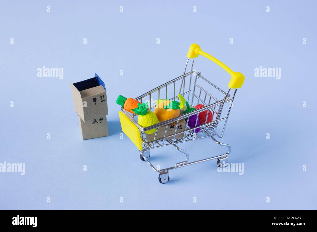 A small grocery cart with fruit and boxes of goods on a purple ...