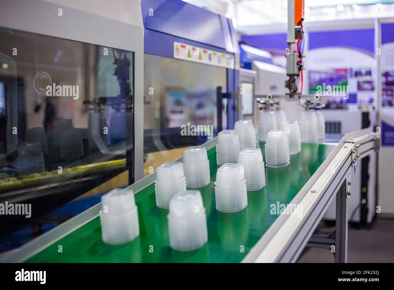 Stack of food containers on conveyor belt of plastic injection molding ...
