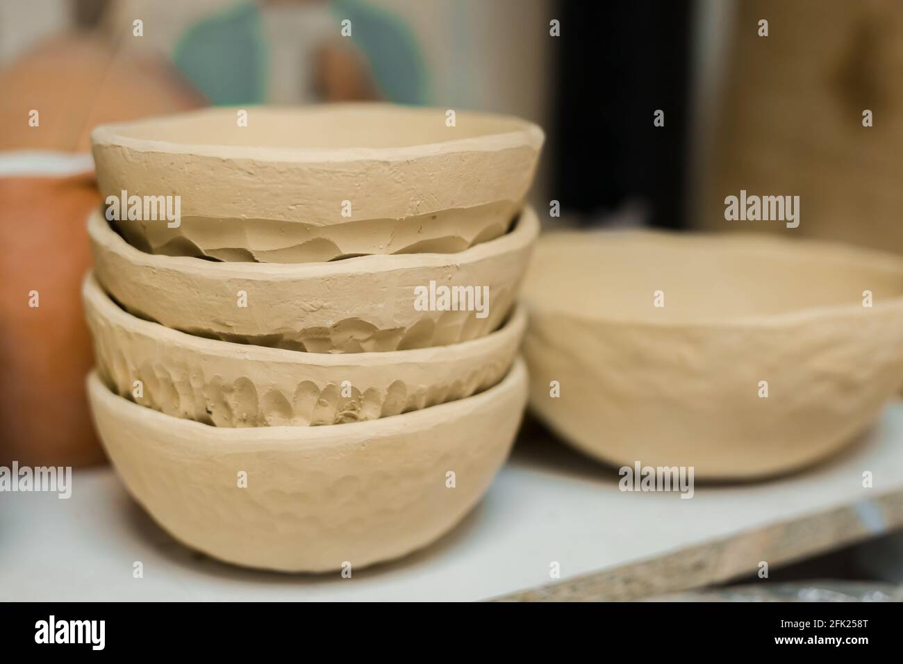 Unfinished clay plates on shelf of pottery workshop - close up Stock ...