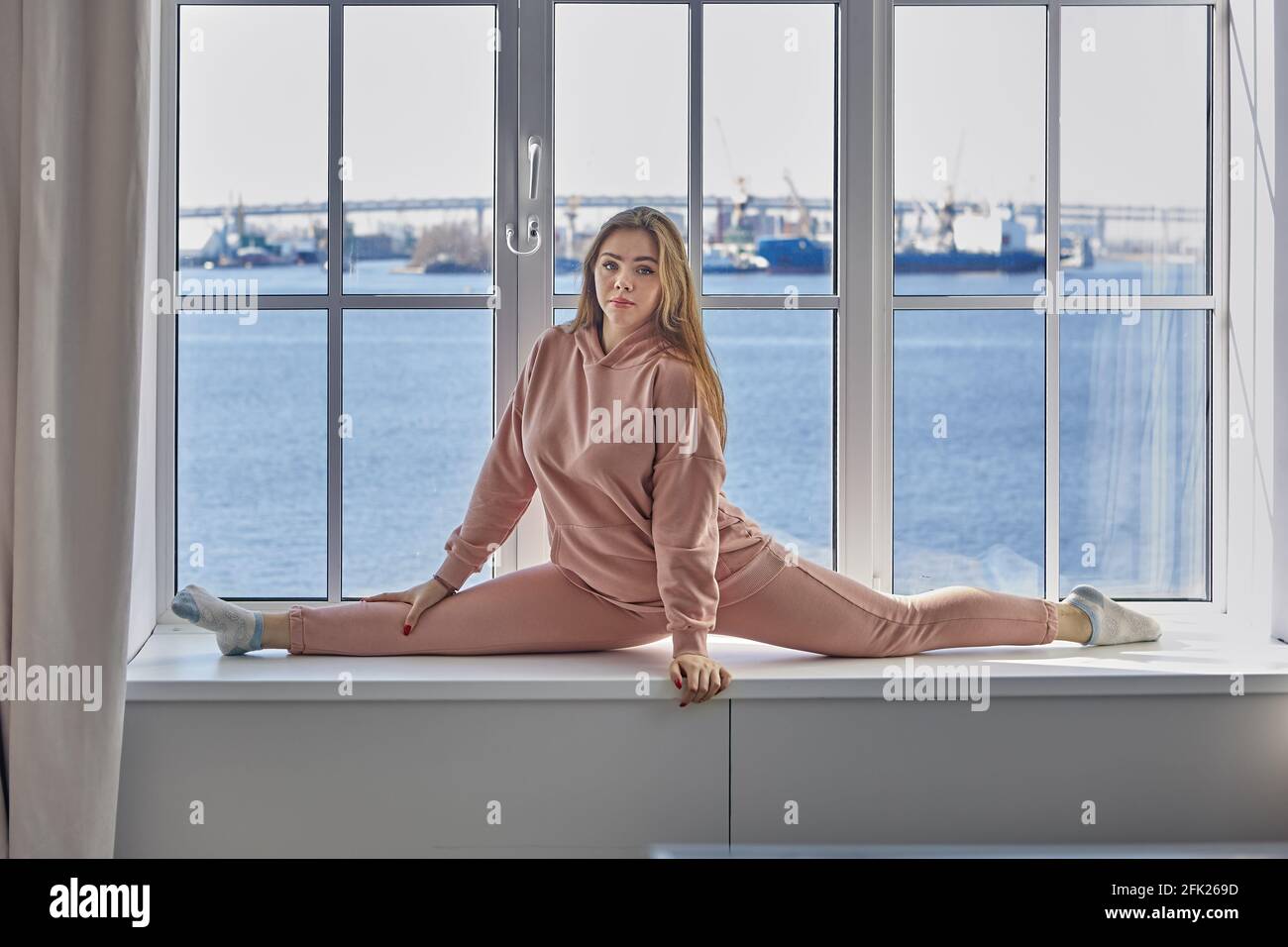 Flexible cheerleader trains at home, she does splits on windowsill ...