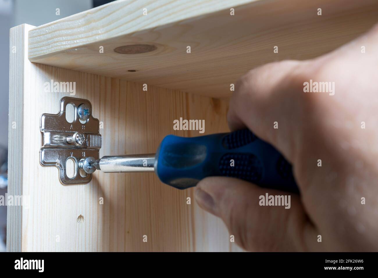 hands with screwdriver screwing hinge on a door Stock Photo - Alamy