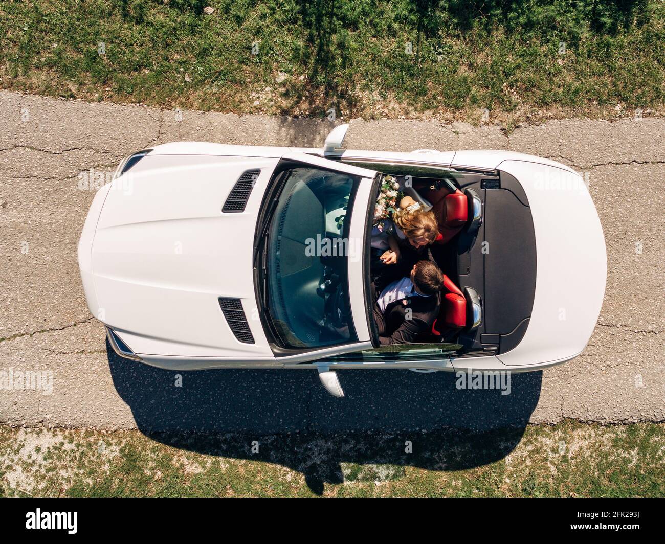 Newlyweds are riding in a beautiful white convertible on the road Stock ...