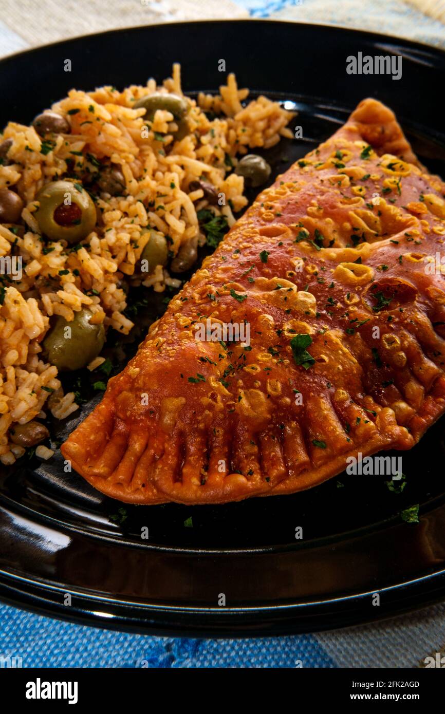 Mexican fried empanada meat pies with olive caper rice Stock Photo - Alamy