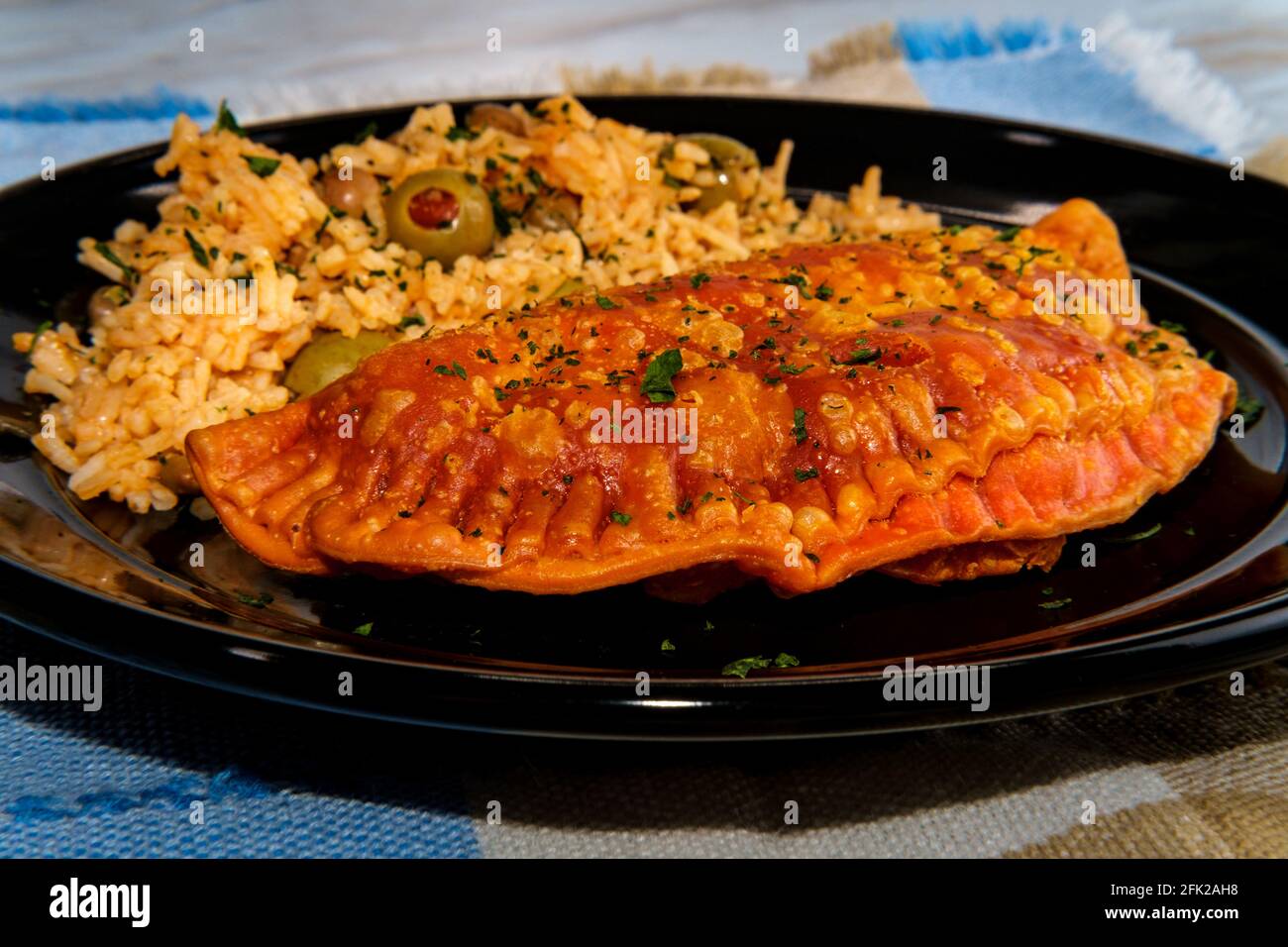 Mexican fried empanada meat pies with olive caper rice Stock Photo - Alamy