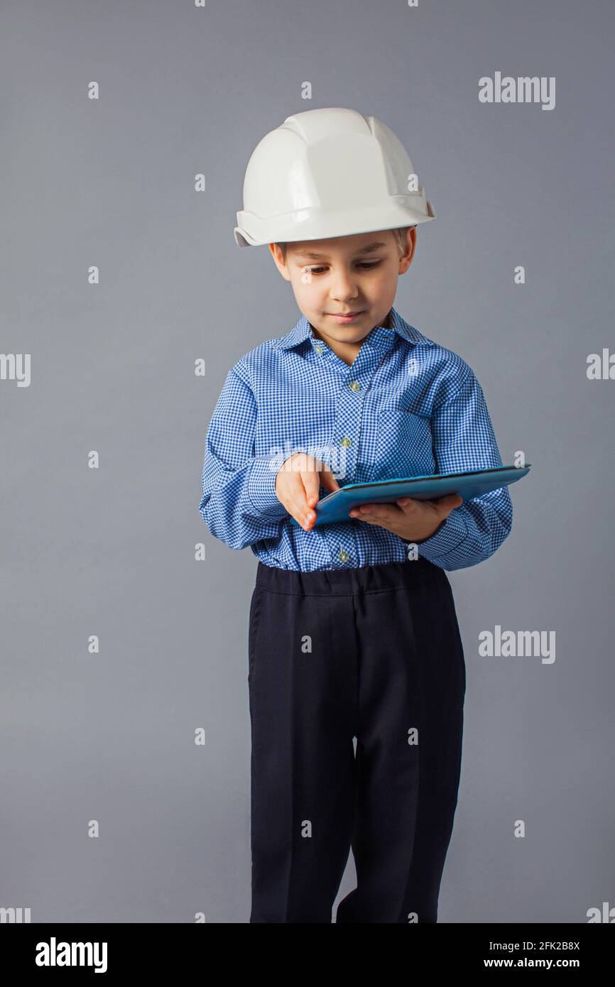 The little boy with tablet dressed in a costume of engineer Stock Photo ...