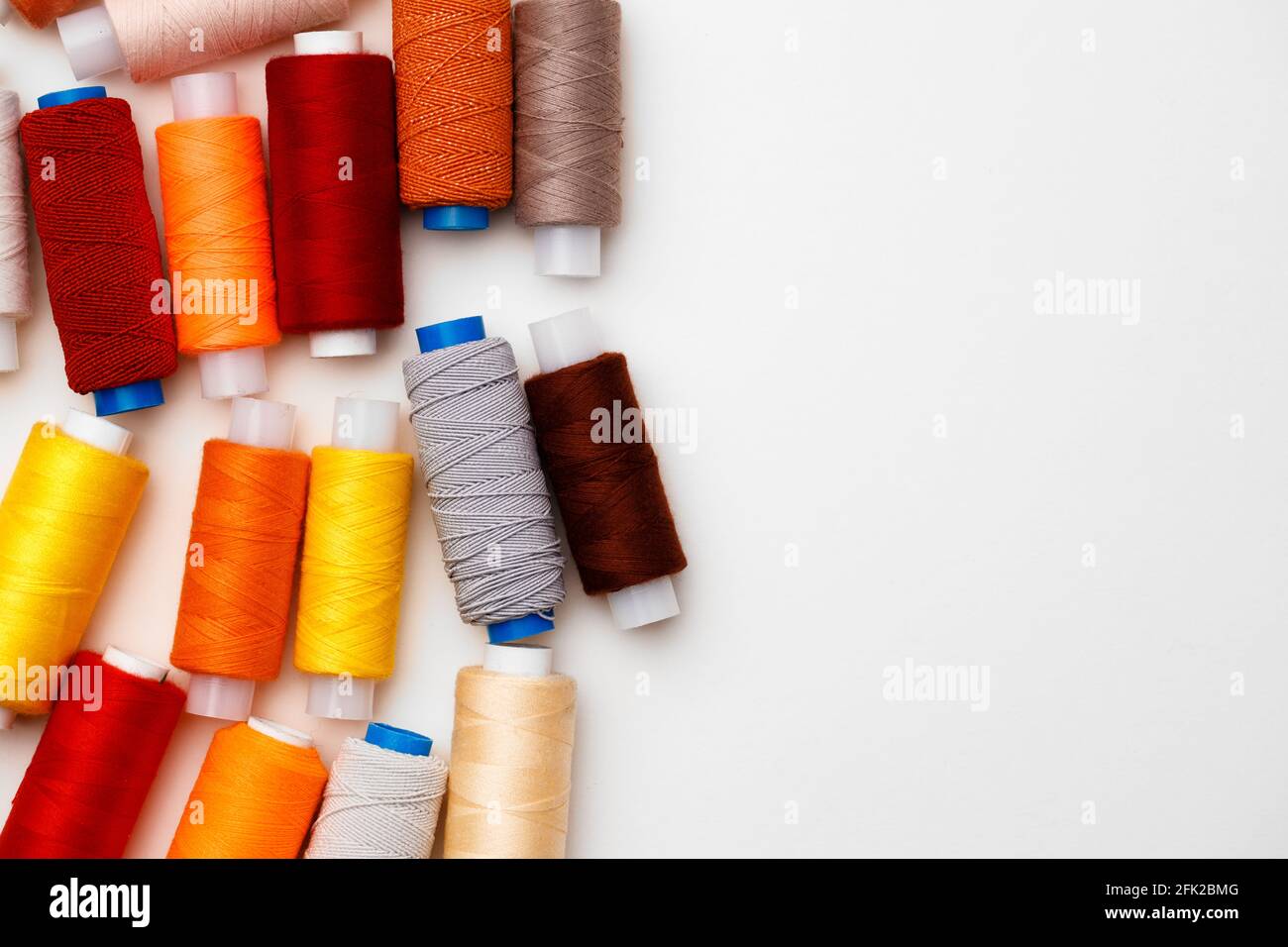 Colored spools of threads on white background Stock Photo - Alamy