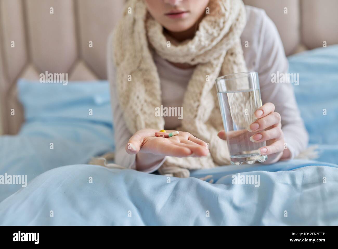 Female taking pills, capsules with glass of water, at home in bed Stock ...