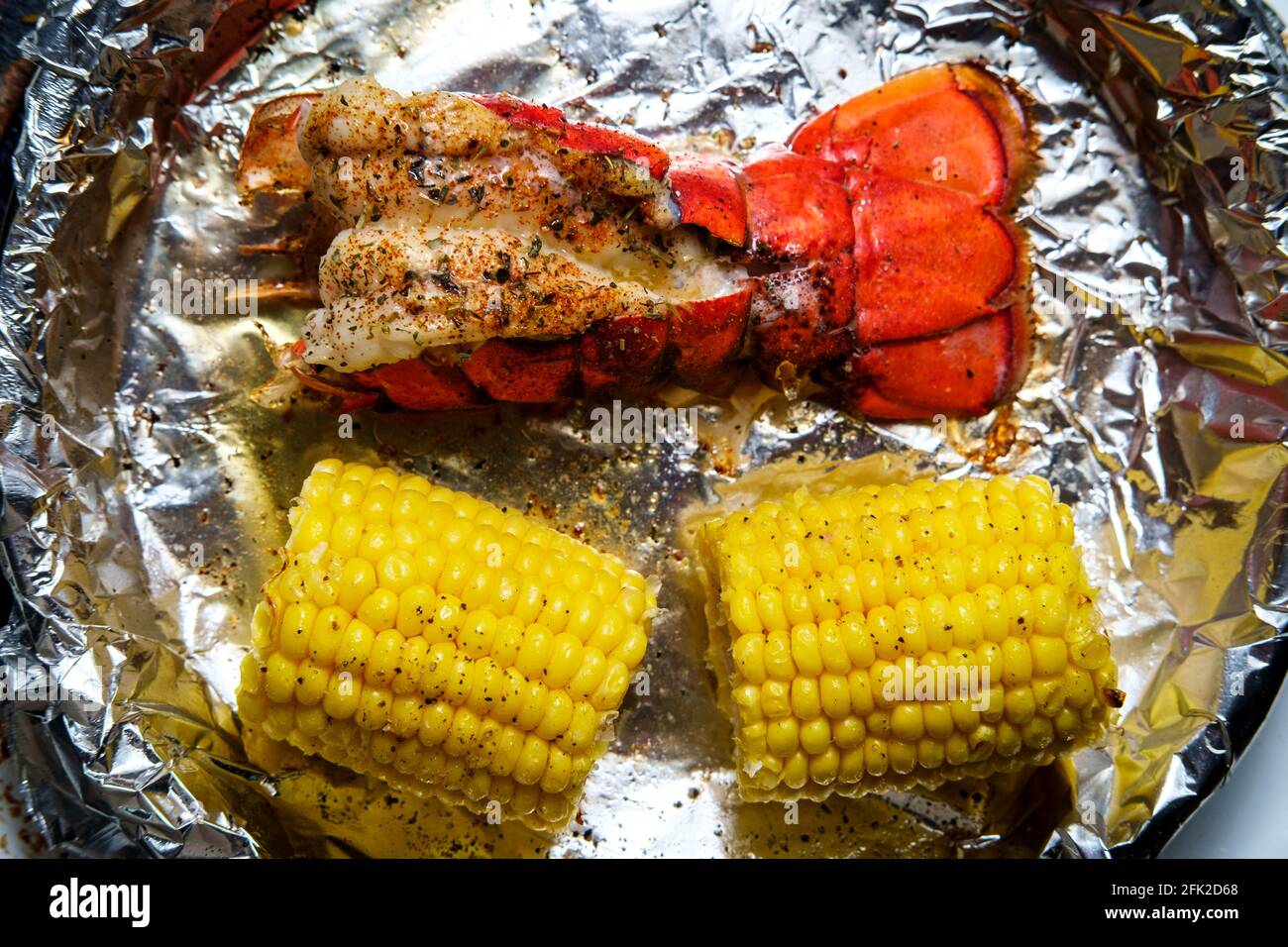 Italian seafood grilled lobster tail with corn on the cob Stock Photo ...