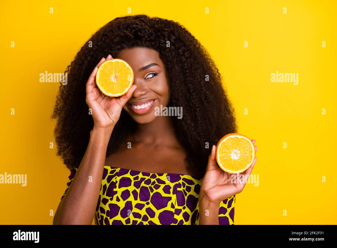 Photo of attractive cheerful dark skin person hold orange cover eye ...