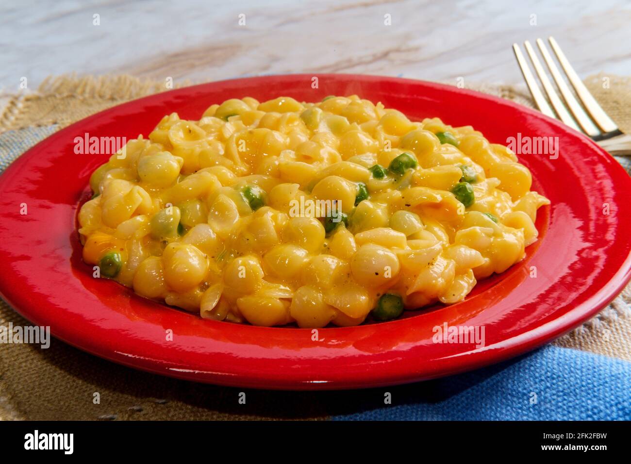 Delicious shell macaroni and cheddar cheese with sweet green peas Stock ...