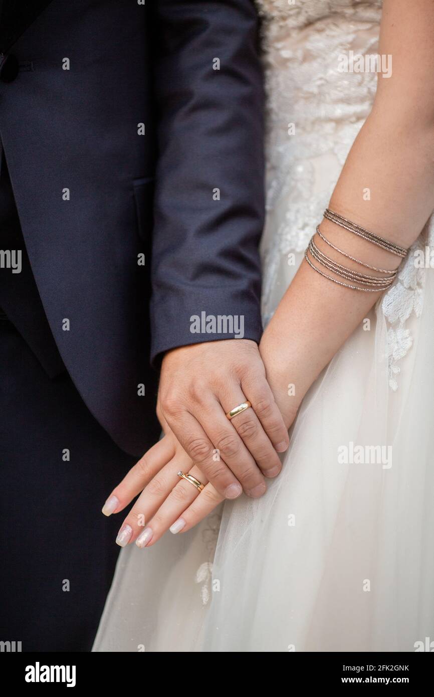 A couple - just married, holding hands and showing their rings at their ...