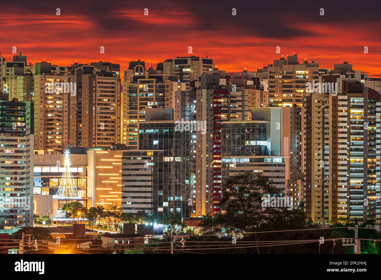 Cityscape at dusk on a powerful sunset and lights of the city turning ...