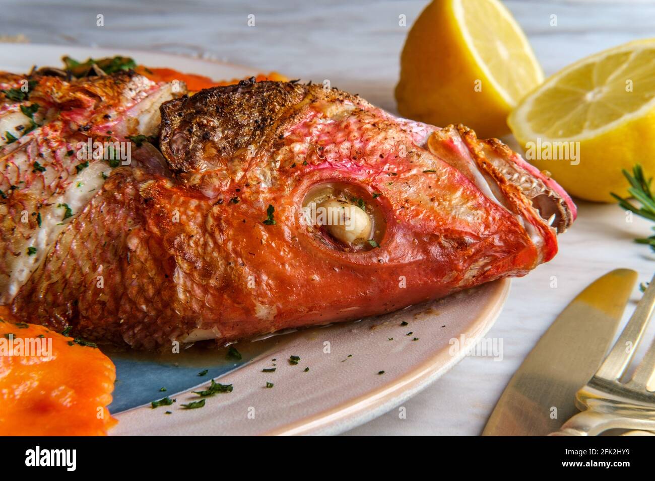 Whole head-on red snapper seafood dinner with ravioli in sherry wine ...