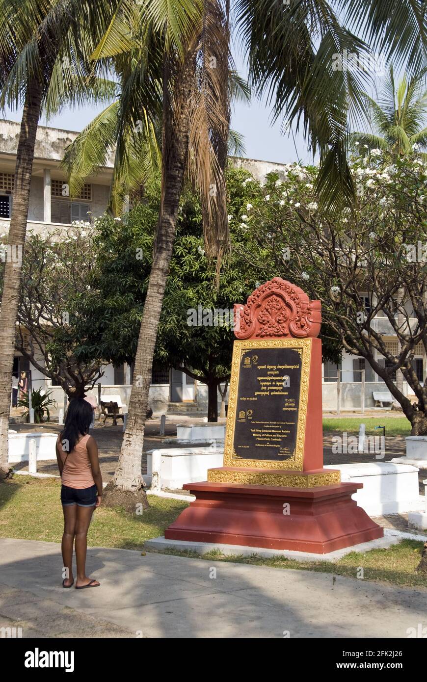 A girl views a monument, with the graves of victims of the Khmer Rouge ...