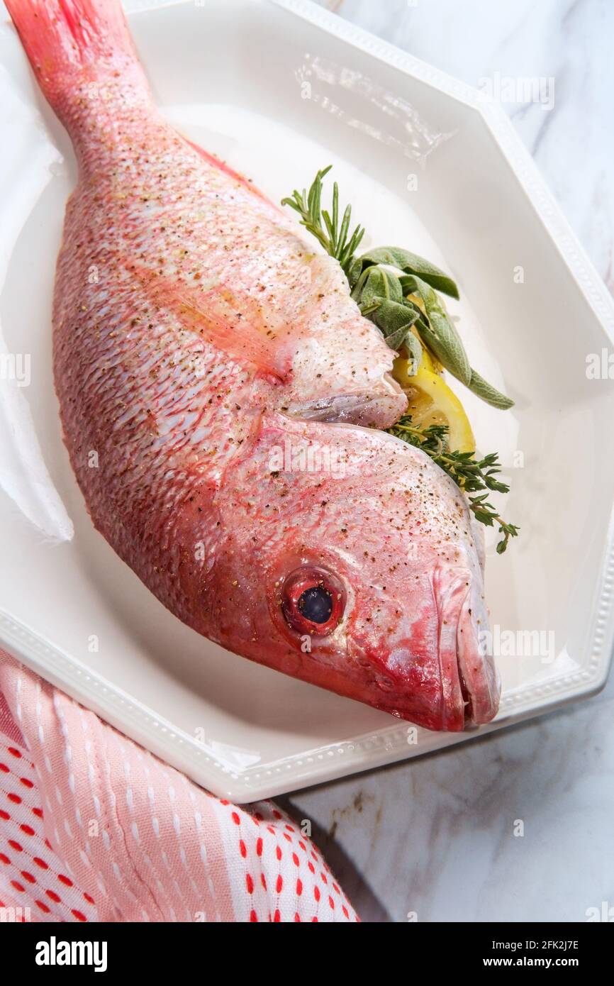 Fresh whole raw head-on red snapper stuffed seasoned and ready to be ...
