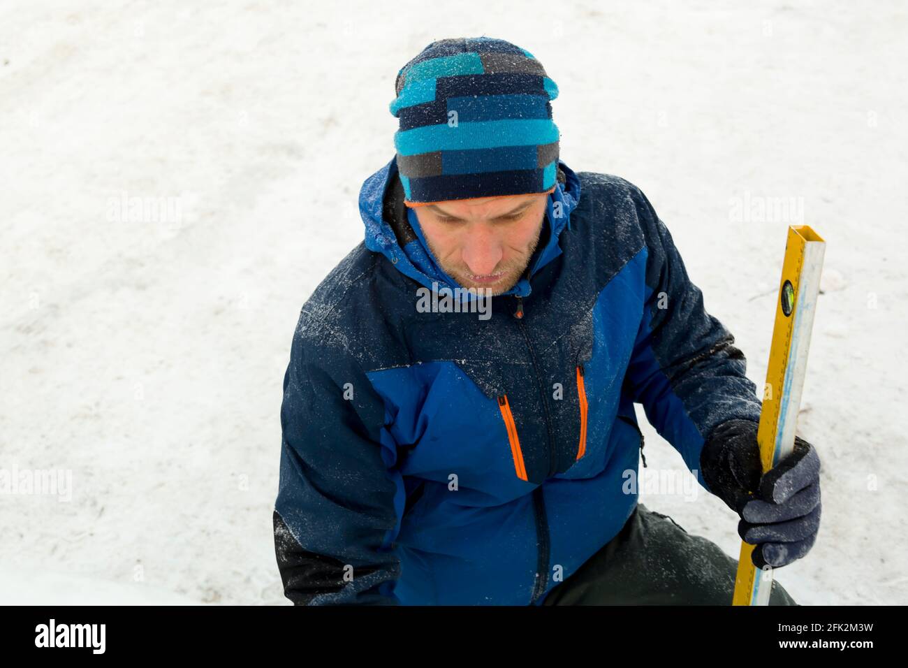 The sculptor cuts an ice figure out of ice with a chisel for Christmas ...