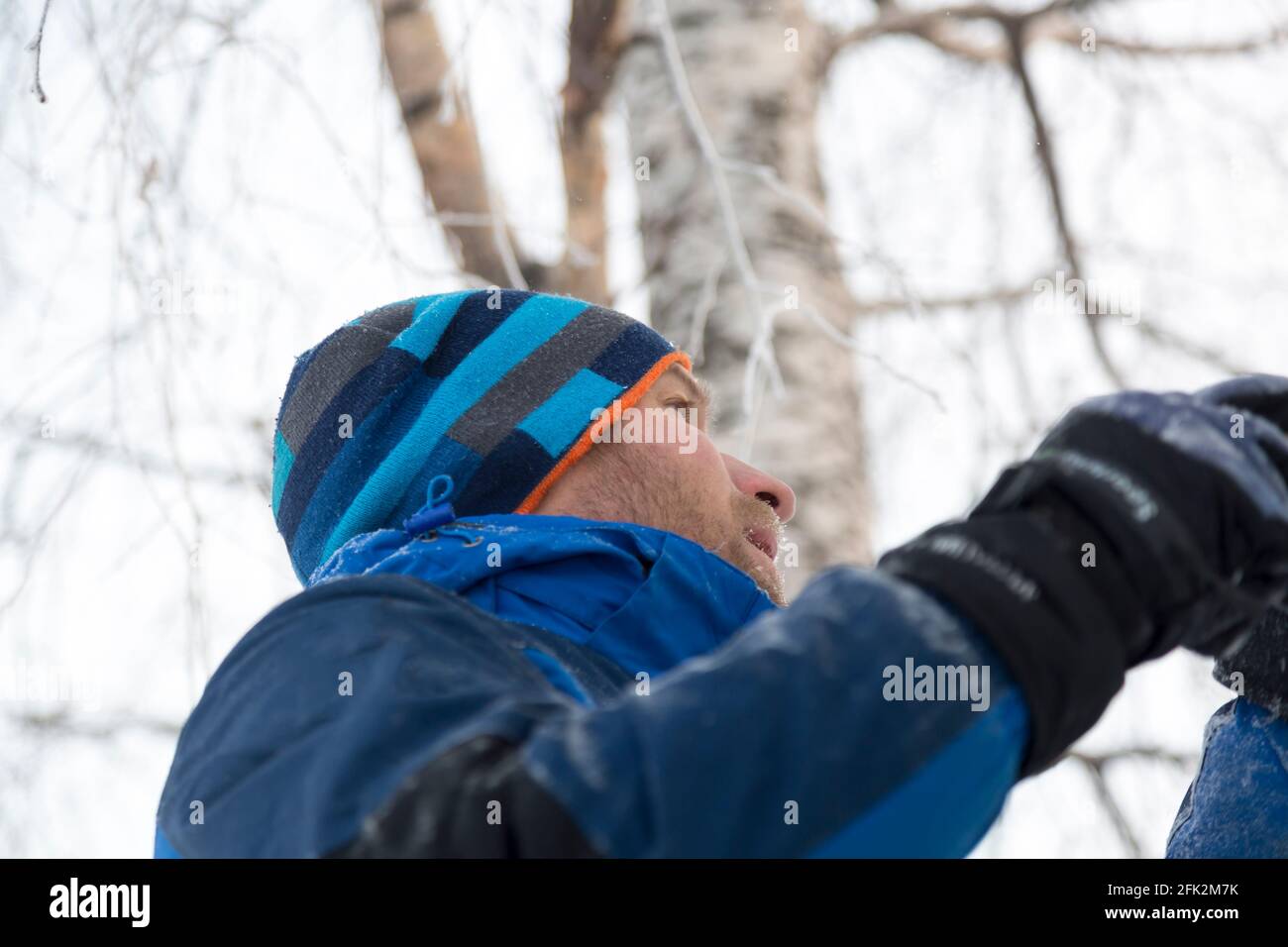 The sculptor cuts an ice figure out of ice with a chisel for Christmas ...