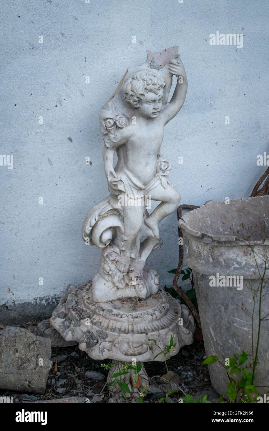 Statue of a Small Broken Angel next to the Garbage Stock Photo - Alamy